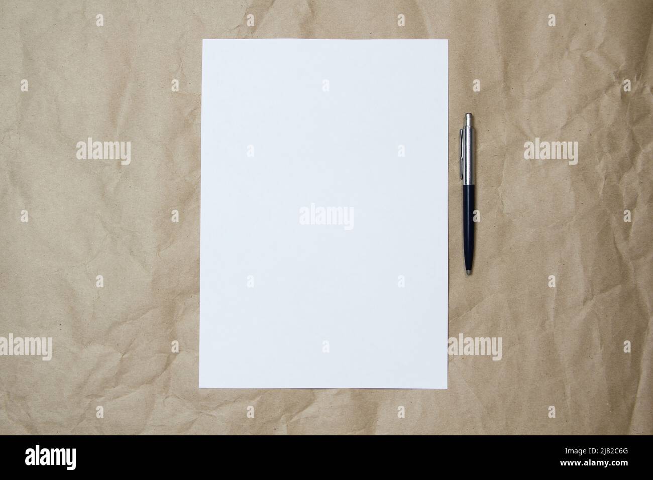 White empty sheet of A4 format with pen on a beige craft paper. Concept ...
