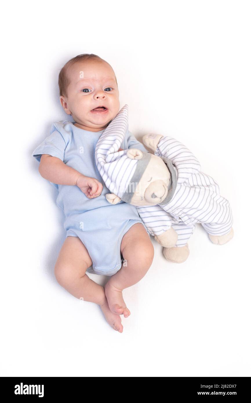 The baby is lying in a crib with a teddy bear . The baby is 0-3 months ...
