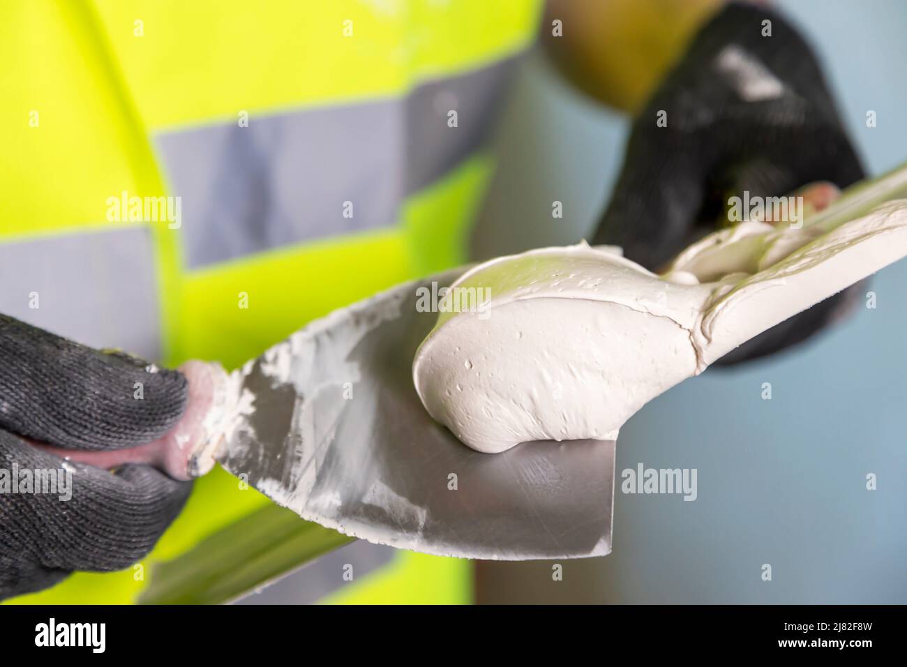 Builder with a spatula in his hands stirs the plaster mixture on a ...