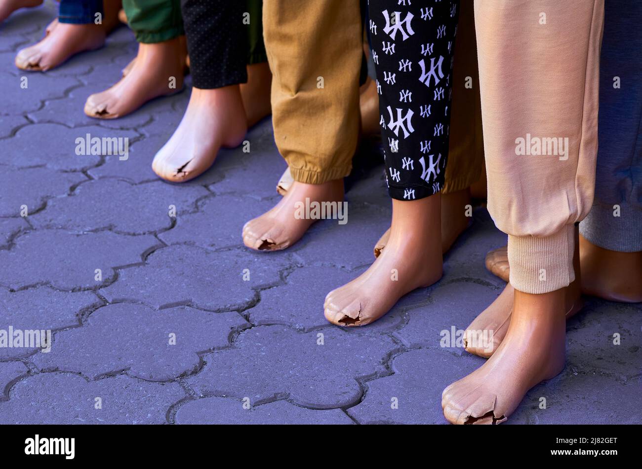 Cracked broken legs of clothing mannequins in trousers on purple floor ...