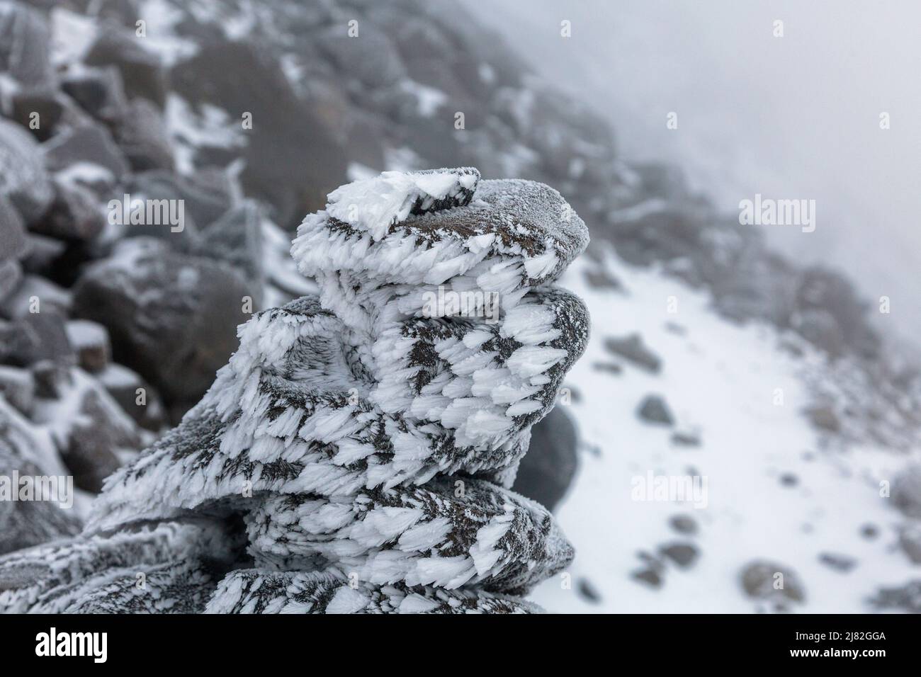 Frozen rocks and stones on the tourist hike path in mountains on the ...
