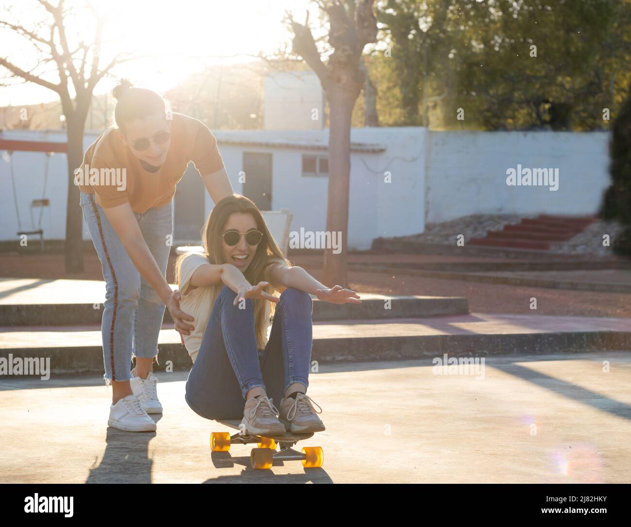Funny young latin couple laughing and playing with their longboards ...