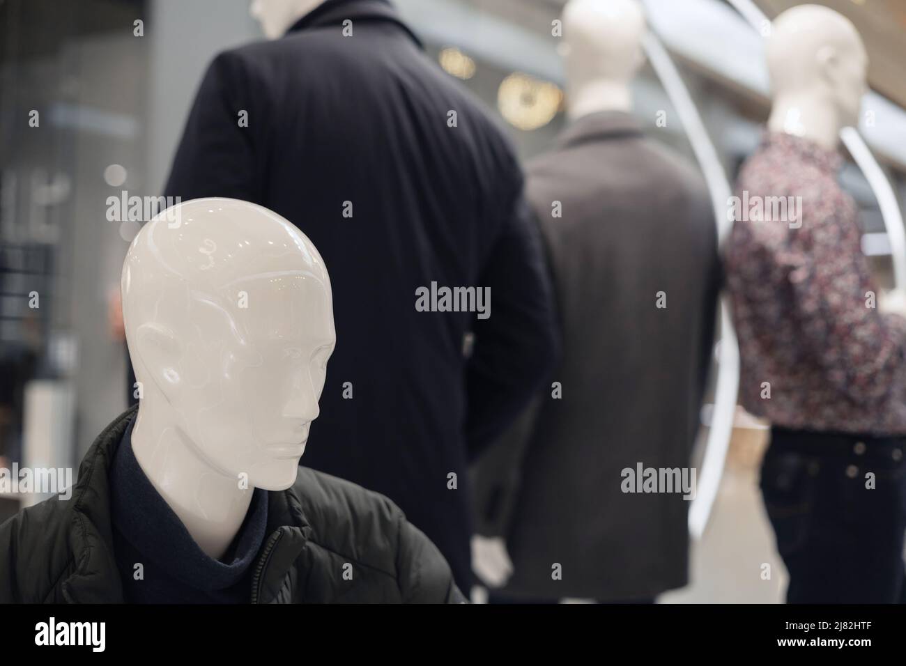 A white male mannequin sits in corner in front of other mannequins in a ...
