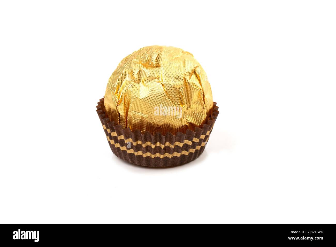 Round candy in a gold package and a paper capsule for a mini cupcake ...