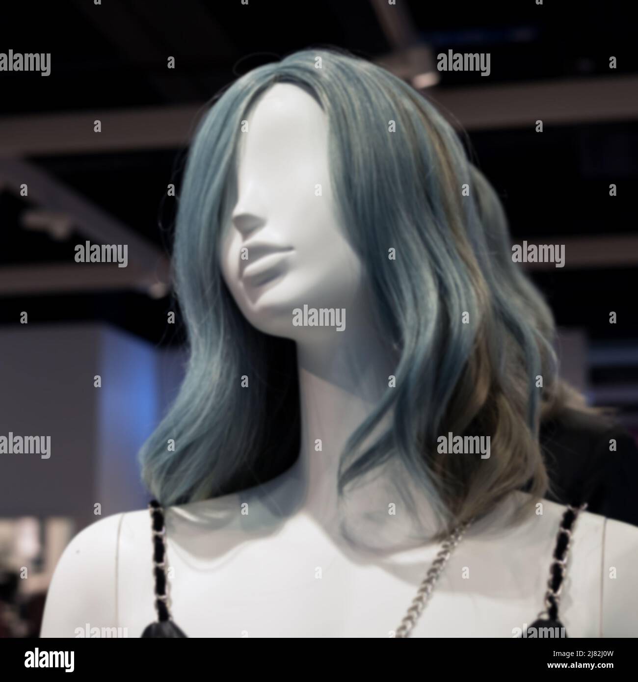 Female mannequin with gray-blue hair. Fashion clothing store. Defocused ...