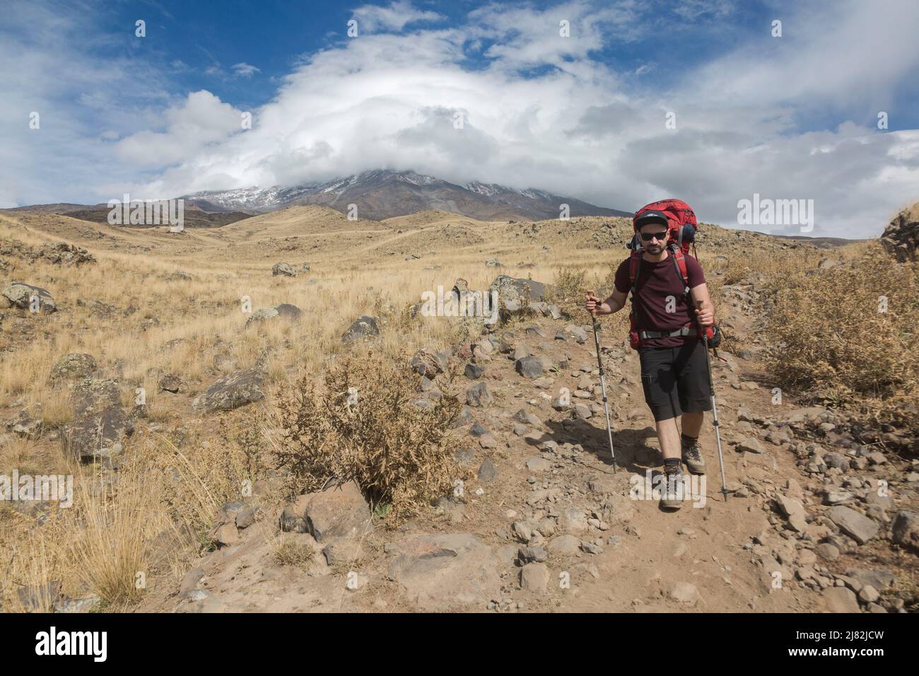 Tourists hike to the snow-capped and dormant compound volcano Mount ...