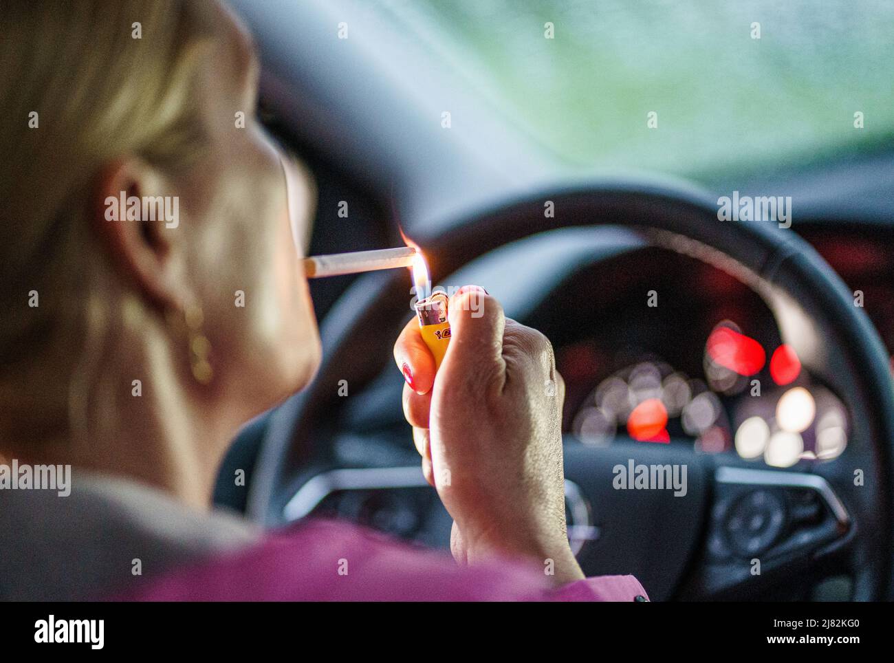 11 May 2022, Schleswig-Holstein, Flensburg: A woman lights a cigarette ...