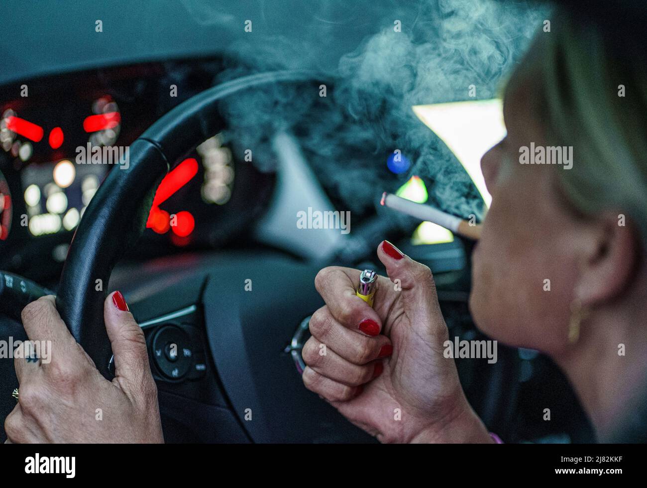 11 May 2022, Schleswig-Holstein, Flensburg: A woman lights a cigarette ...
