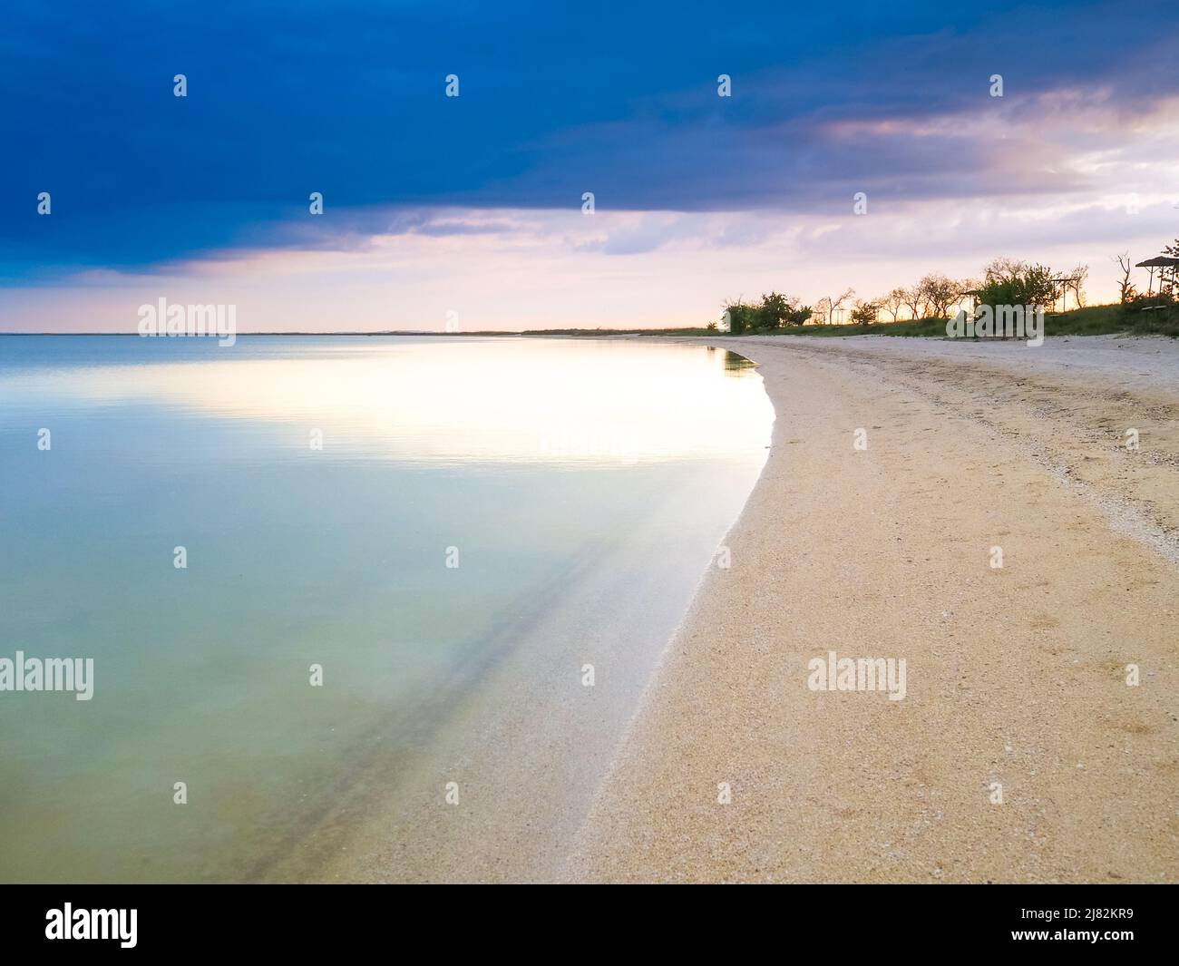 Panoramic view of the sandy shore of the Sea of Azov at sunset. Cloudy ...