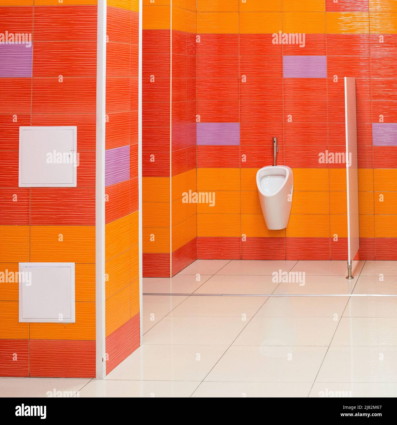 Bright orange toilet public restroom decor elements Stock Photo - Alamy