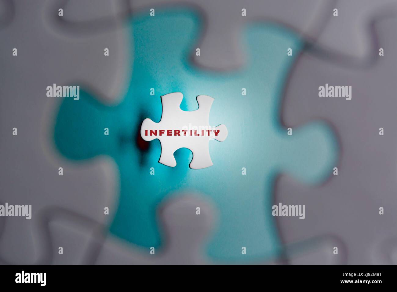 Infertility word on puzzle pieces isolated on blue background. IVF ...