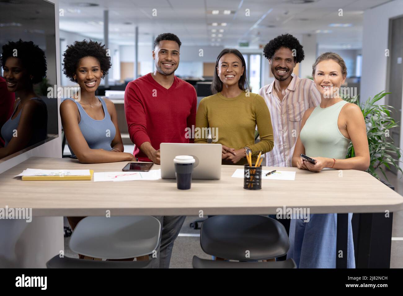 Team of happy male and female biracial advisors with laptop at desk ...
