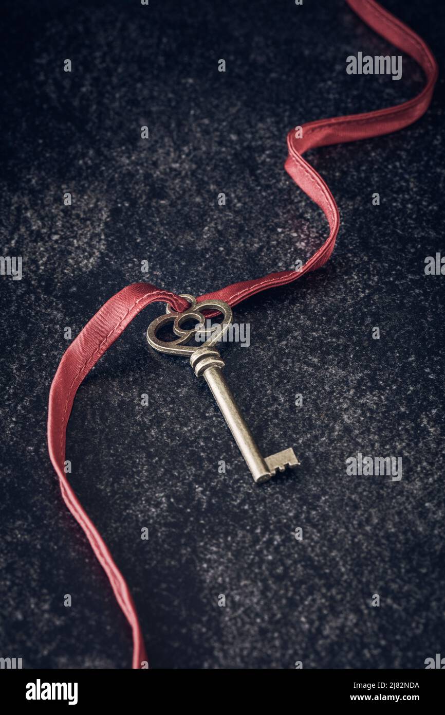 Small key on red ribbon Stock Photo - Alamy
