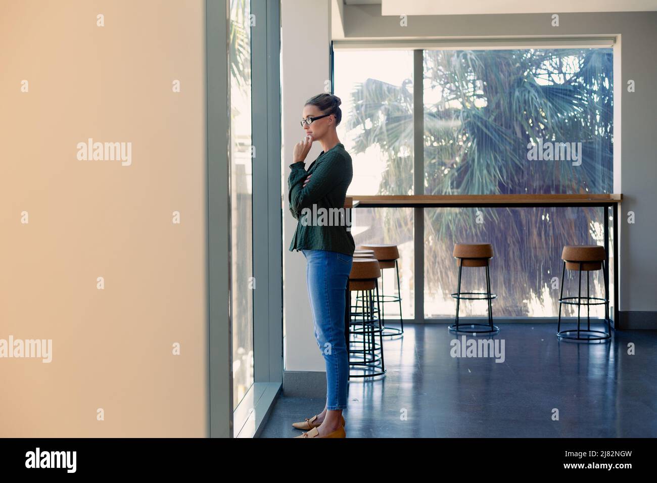 Full length of caucasian female advisor thinking while looking out ...