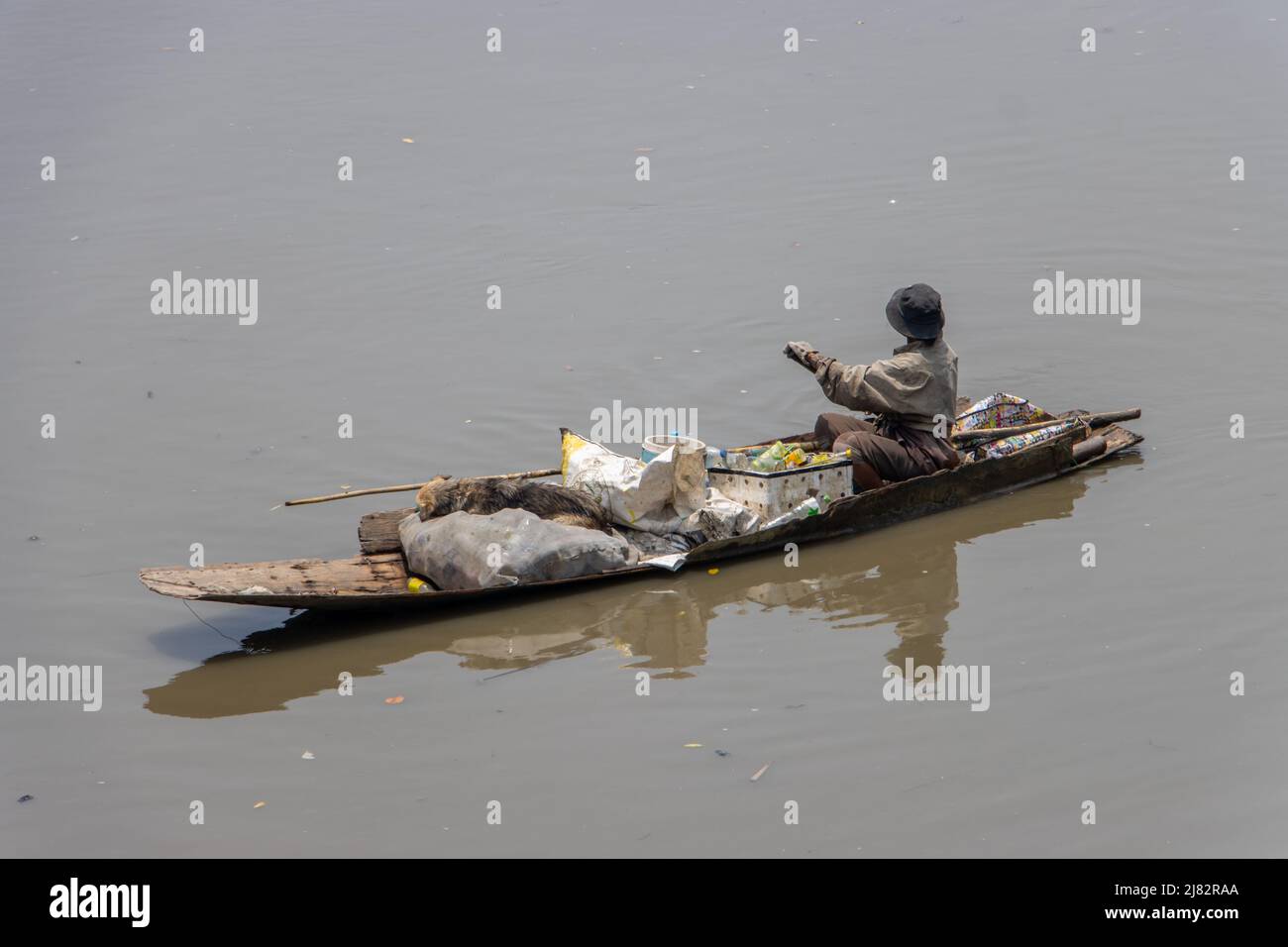 A poor human floats on an old boat full of recycled materials Stock ...