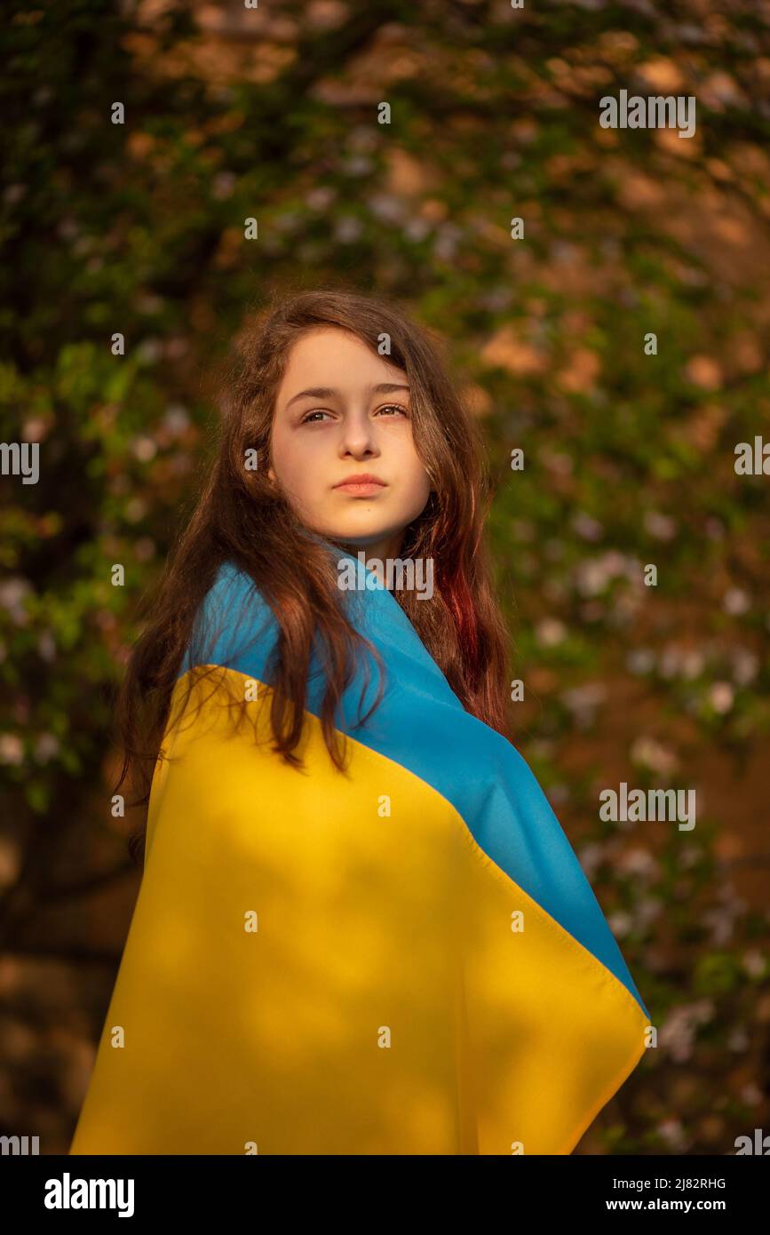 The girl is standing with the Ukrainian flag. Yellow and blue fabric ...