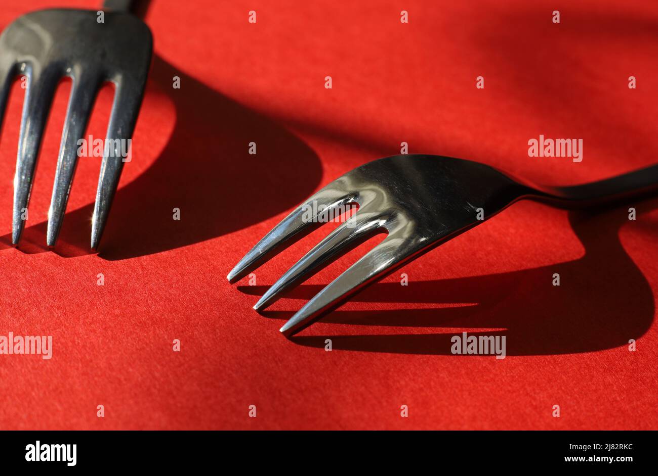 metal fork with reflection on red background Stock Photo - Alamy