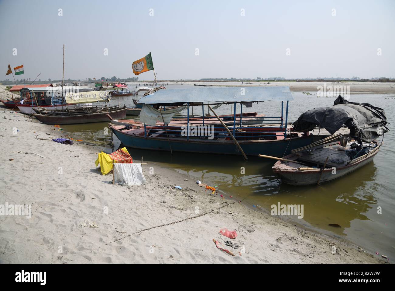 Floating desi boats in shallow riverbed of the holy Ganges in scorching ...
