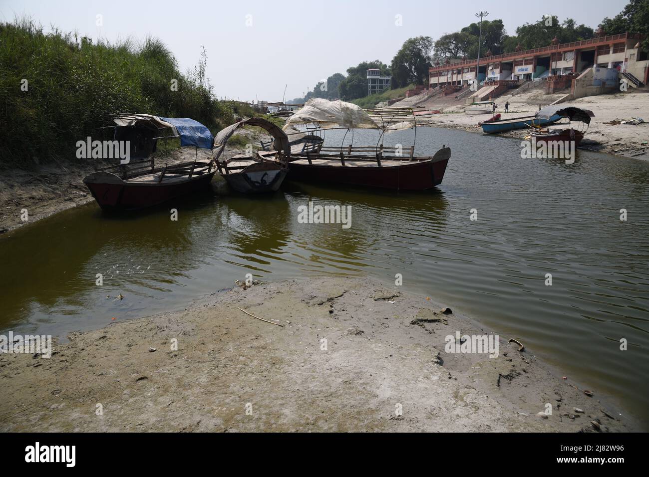 Floating desi boats in shallow riverbed of the holy Ganges in scorching ...