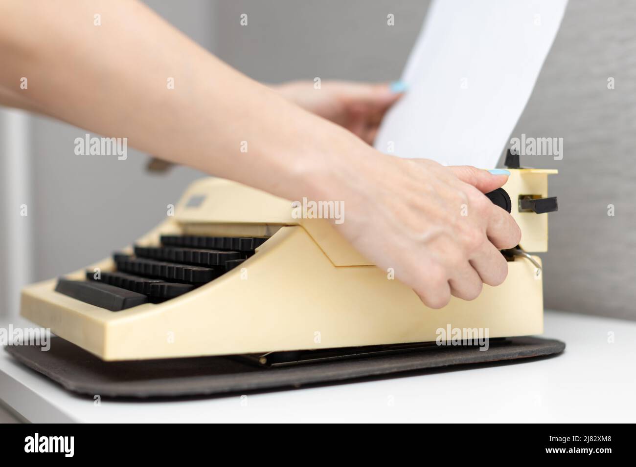 a woman is loading paper into a typewriter while turning the roller ...