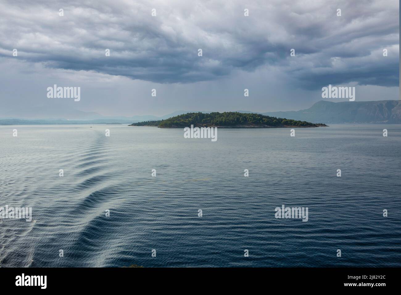 the wake of a sea bound cruise ship in the distance a tree covered ...