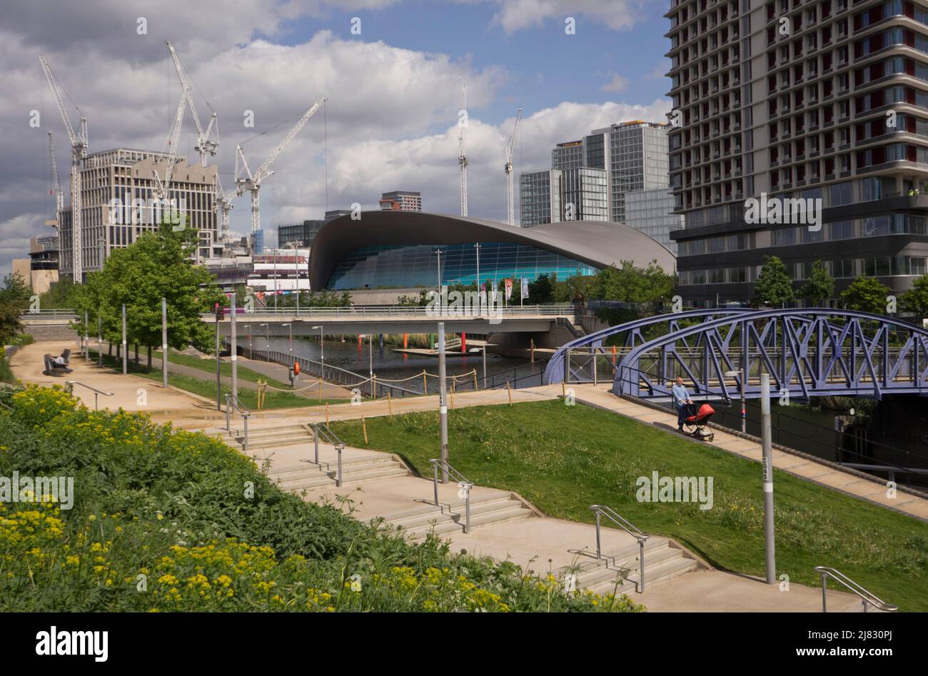Man pushing pram with baby with construction site at the East Bank ...