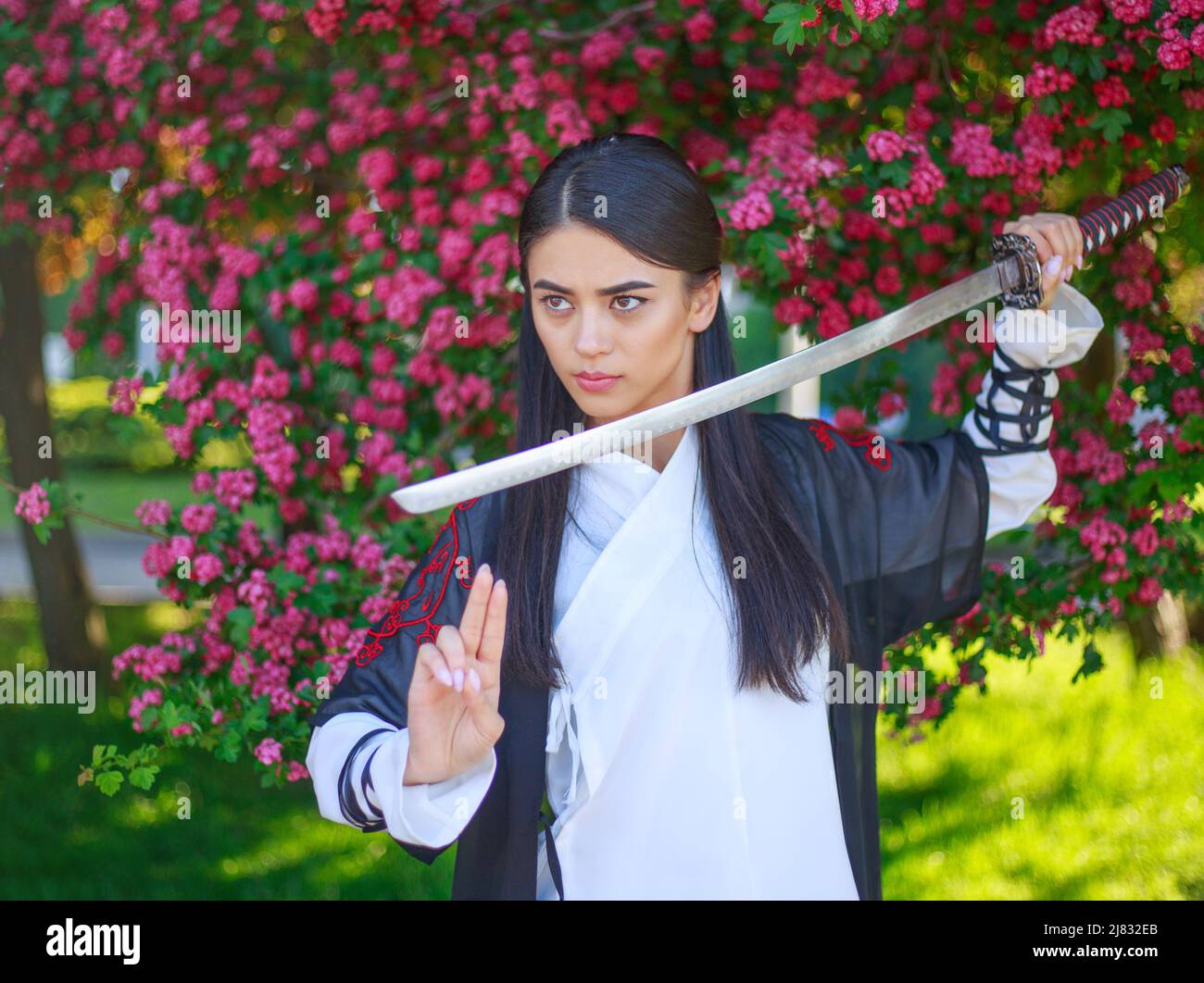 Elegant girl in a traditional kimono in a blooming flowers garden with ...