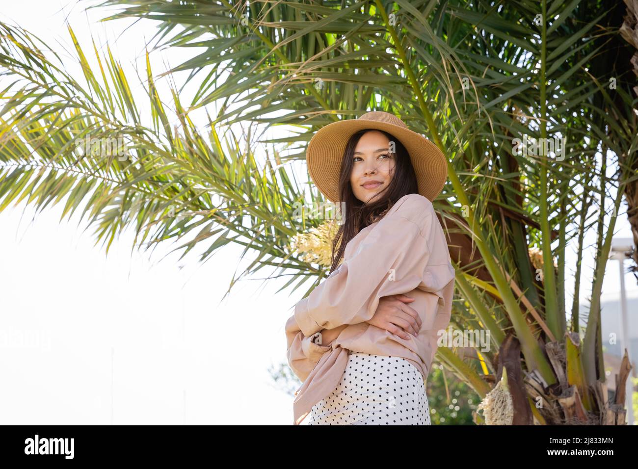 Low angle view of woman standing with her arms crossed hi-res stock ...