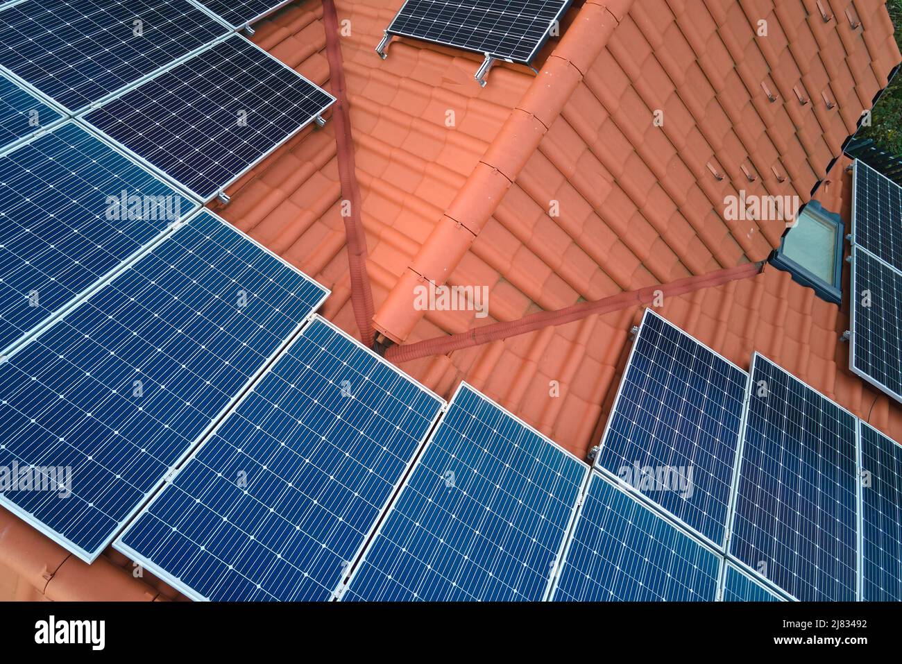 Aerial view building roof with rows of blue solar photovoltaic panels ...