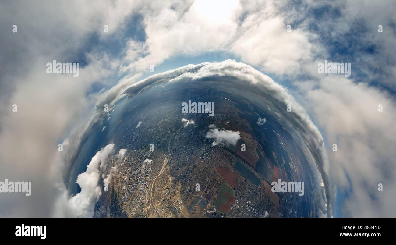 Aerial view from high altitude of little planet with distant city ...