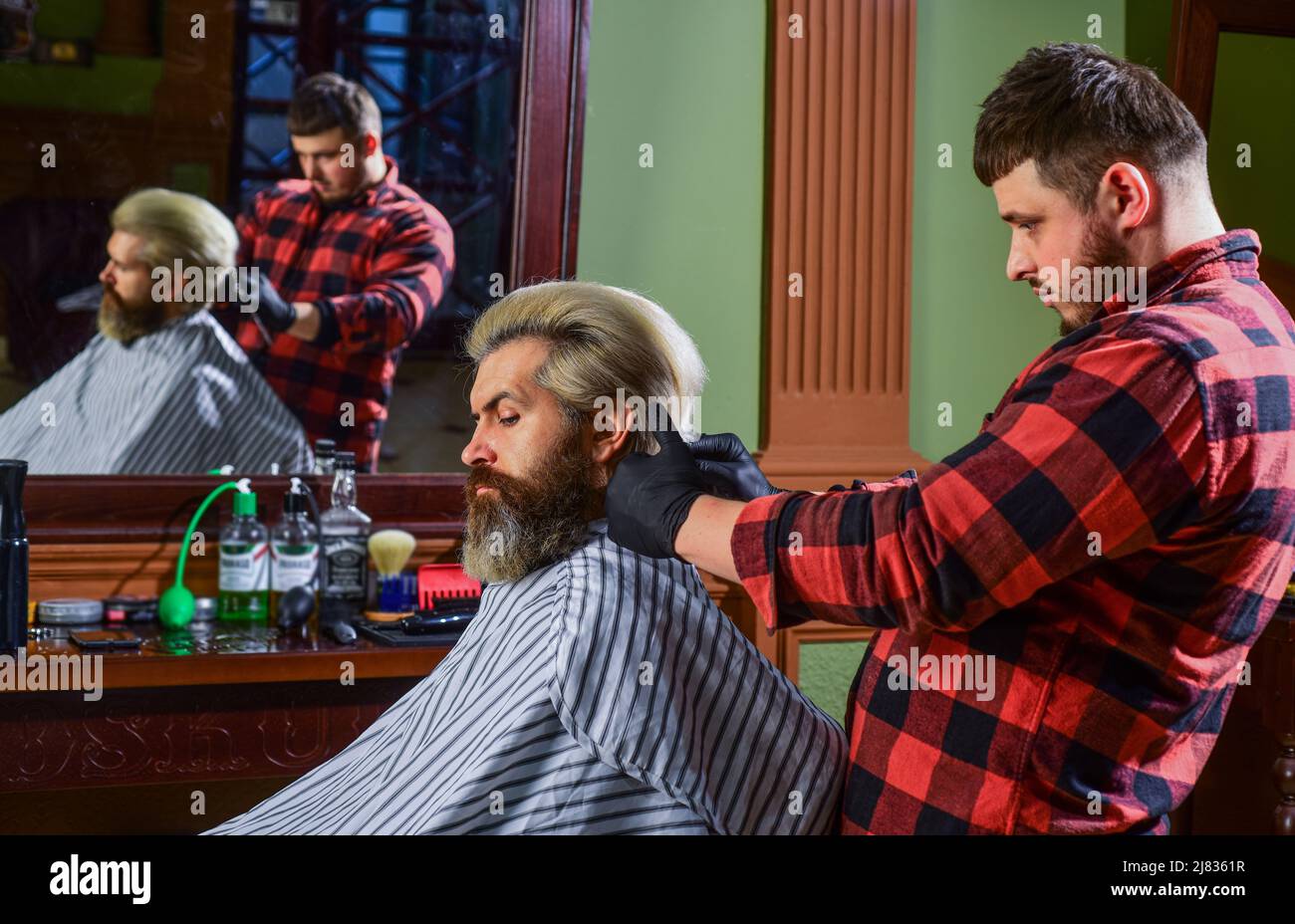 Lifestyle. master barber does the hairstyle and styling with dryer ...