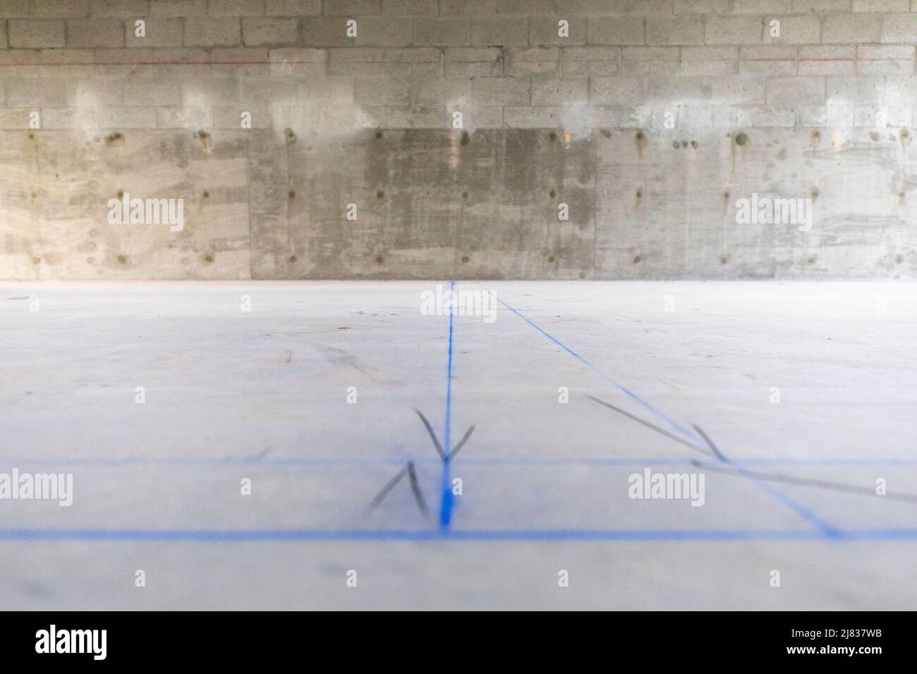 Blue framing markings on a concrete slab floor used to guide where ...