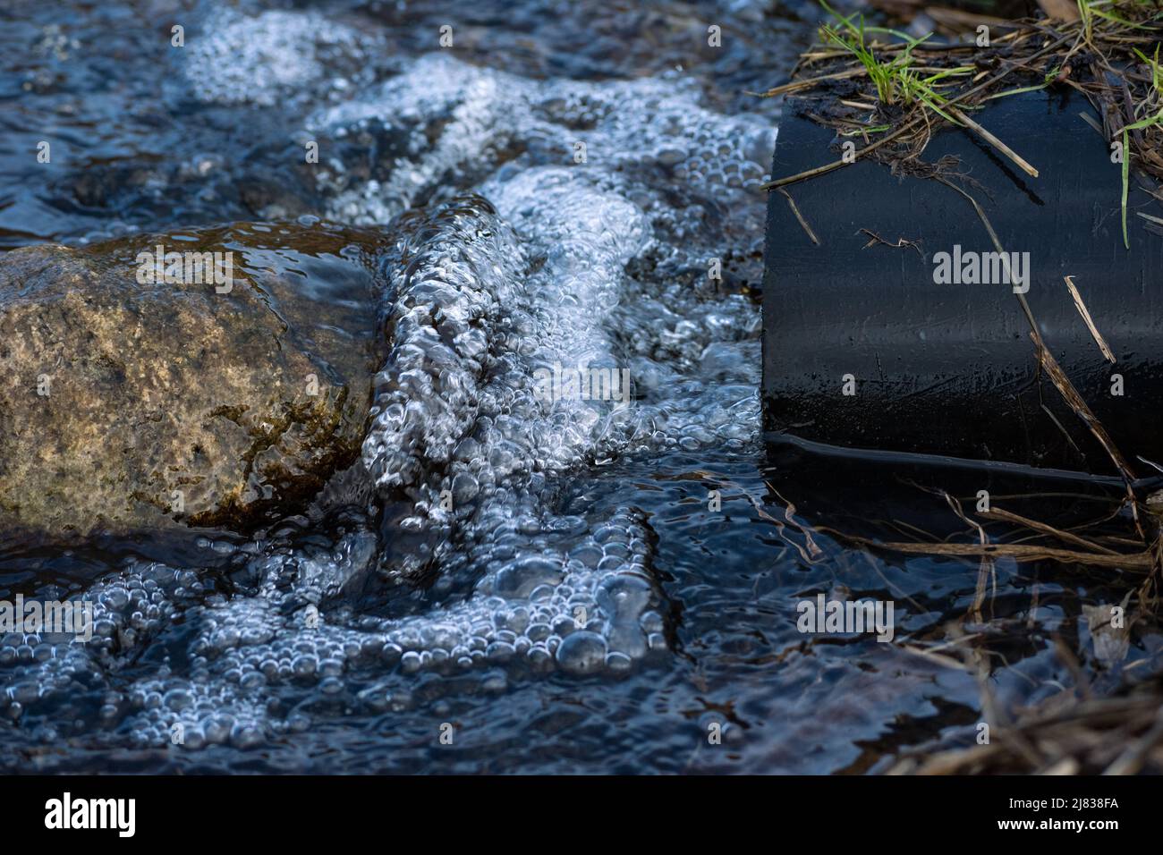 Water coming out of a pipe, and hitting a rock Stock Photo - Alamy