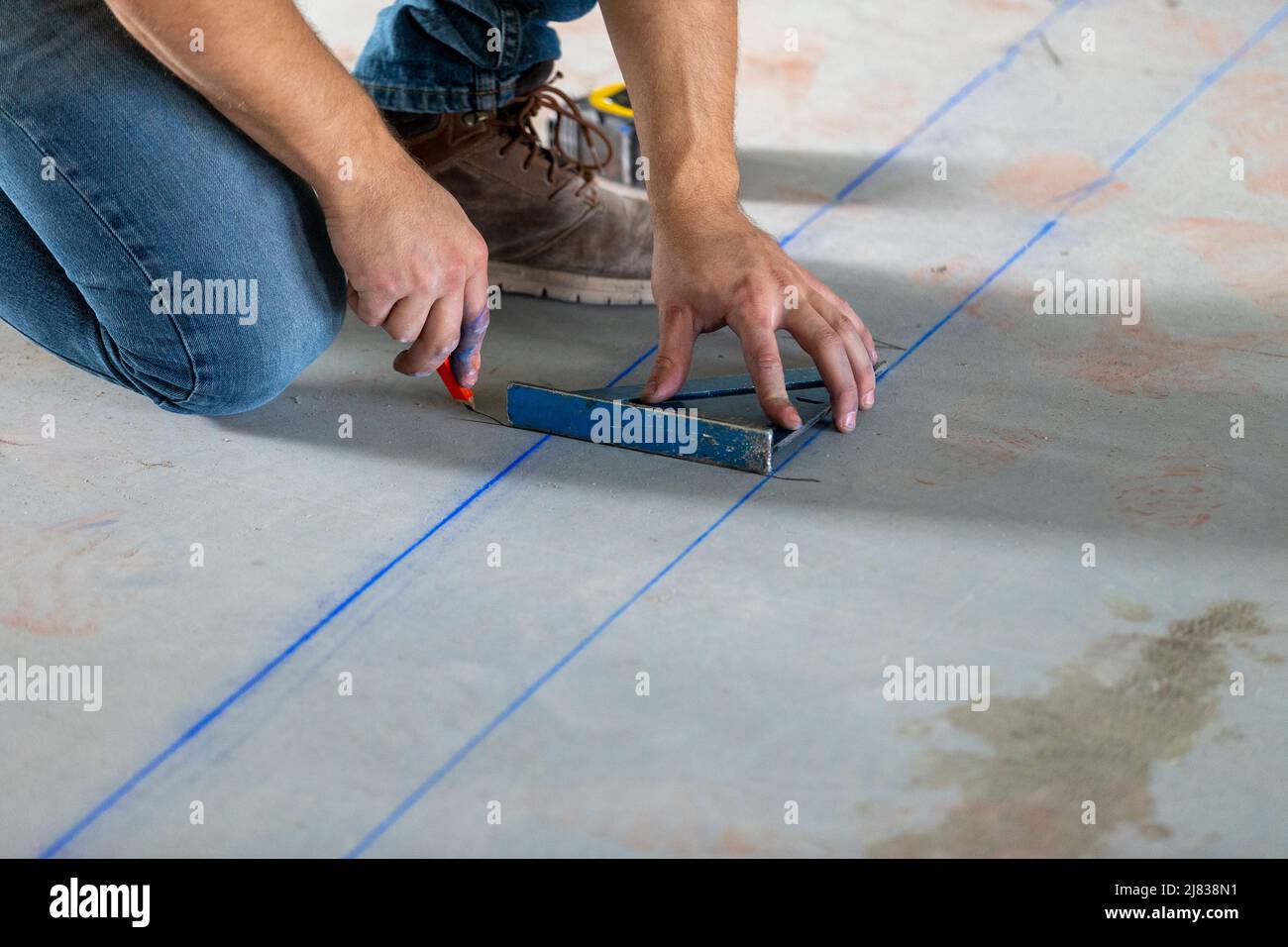Construction worker measuring and outlining the floor of an affordable ...
