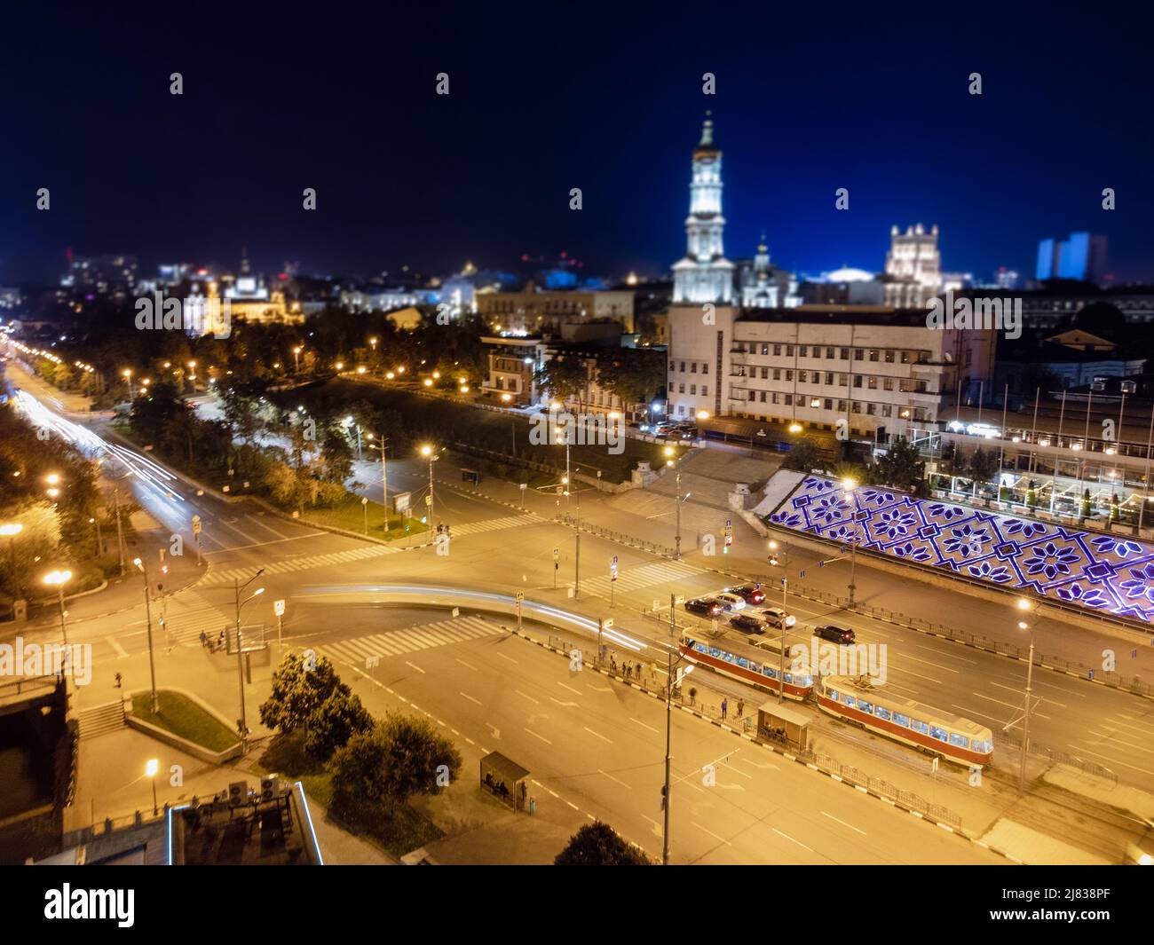 Night city center streets with tram and cars driving in long exposure ...