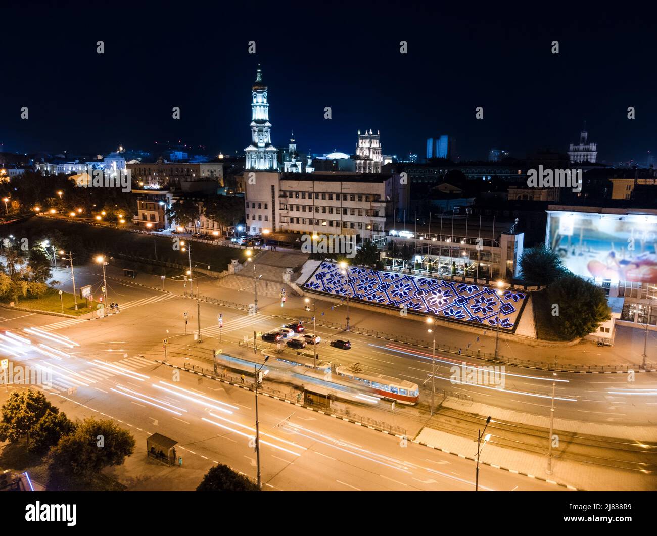 Night city center streets with tram and cars driving in long exposure ...