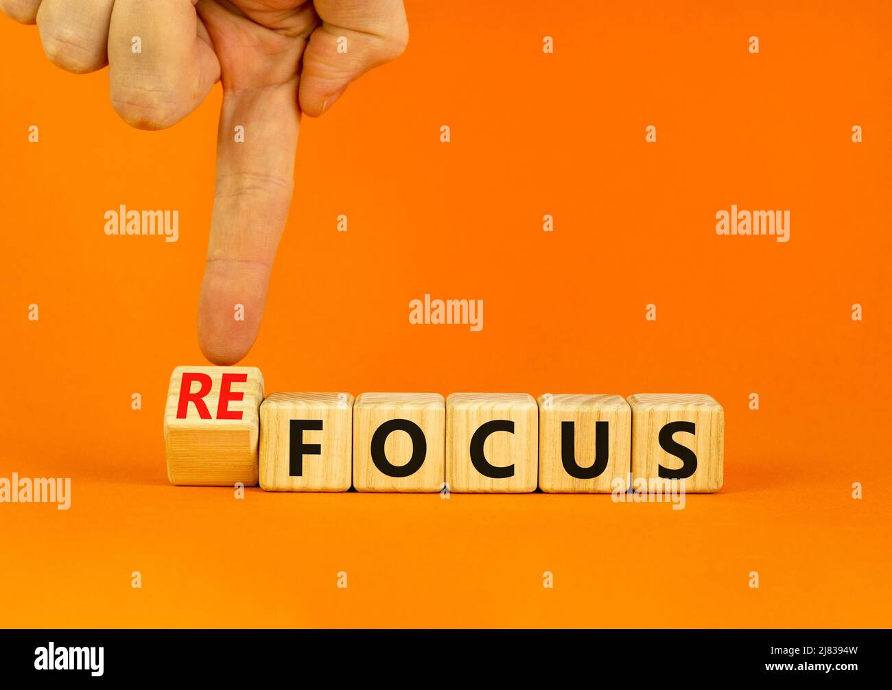 Focus or refocus symbol. Businessman turns wooden cubes and changes the ...