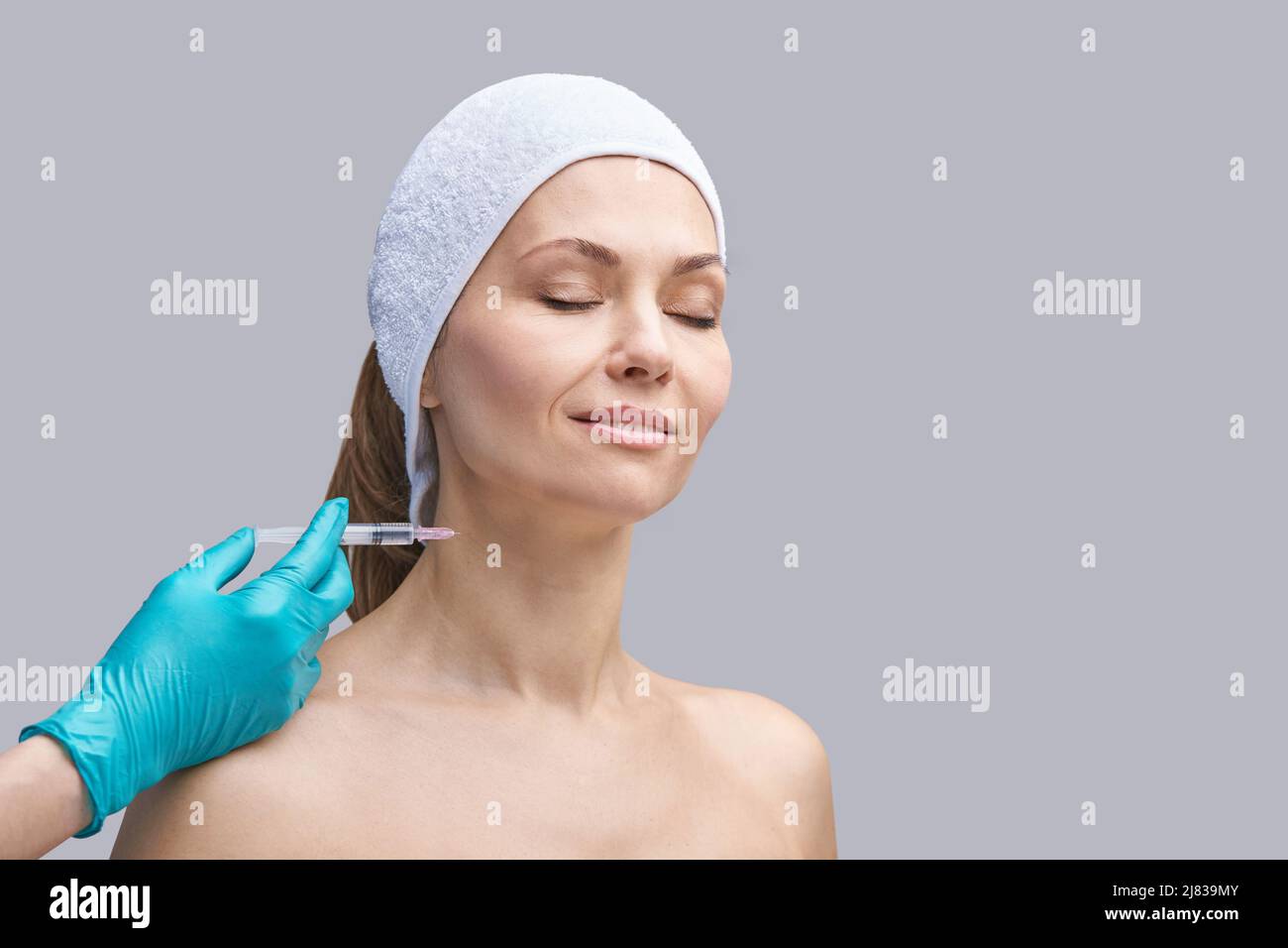 Face needle injection. Young woman cosmetology procedure. Doctor hand ...