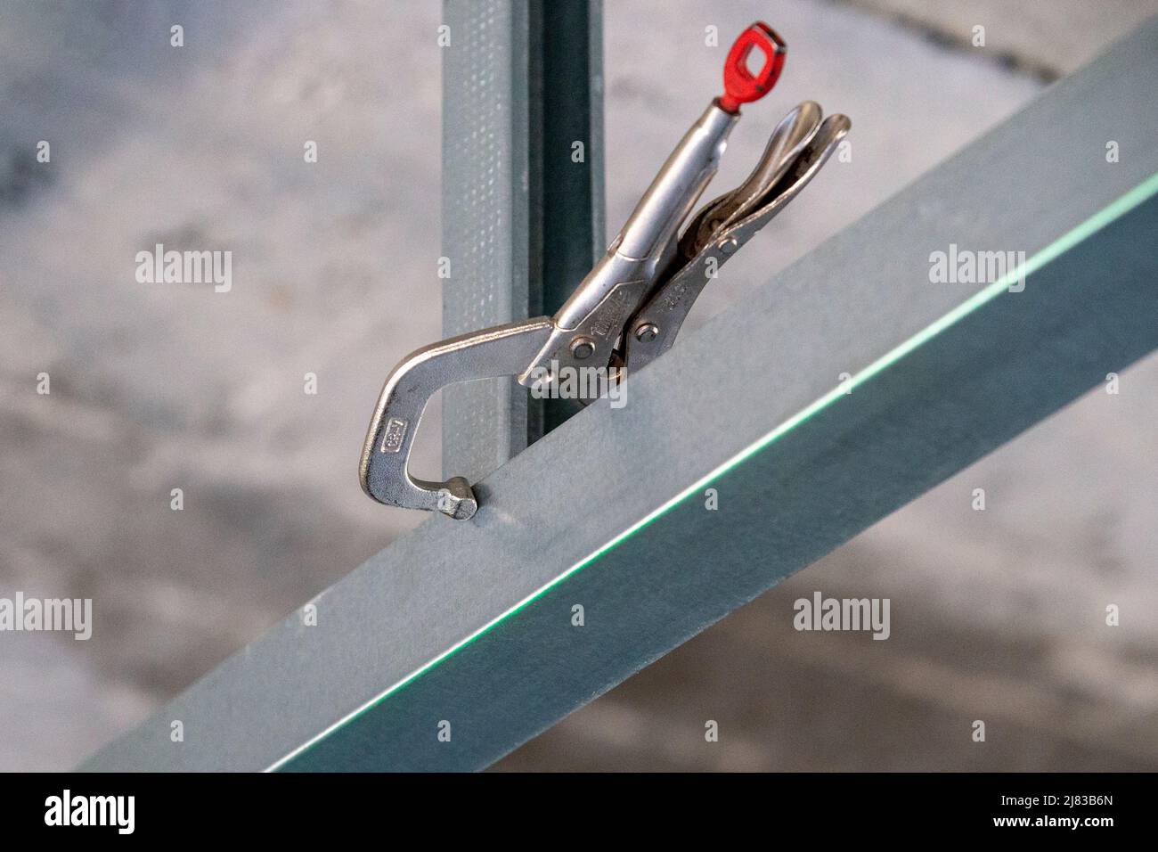 A piece of ceiling framing being installed under the ceiling of a new ...