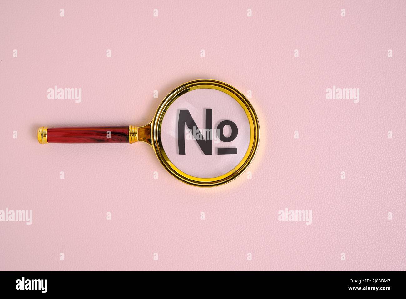 Sign No. under magnifying glass, on pink background Stock Photo - Alamy