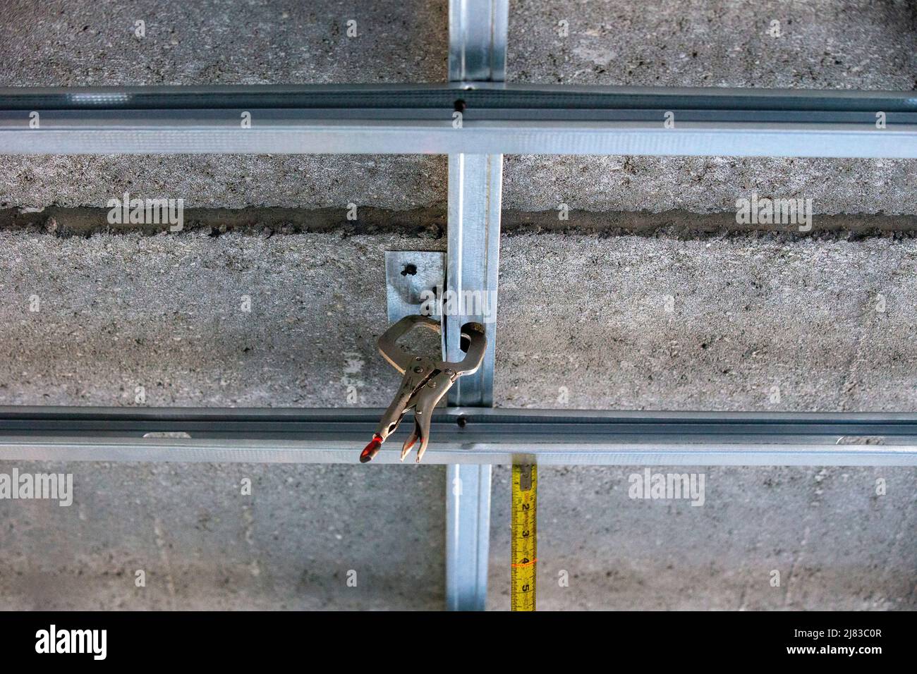 Ceiling metal struts are clamped and installed for ceiling drywall ...