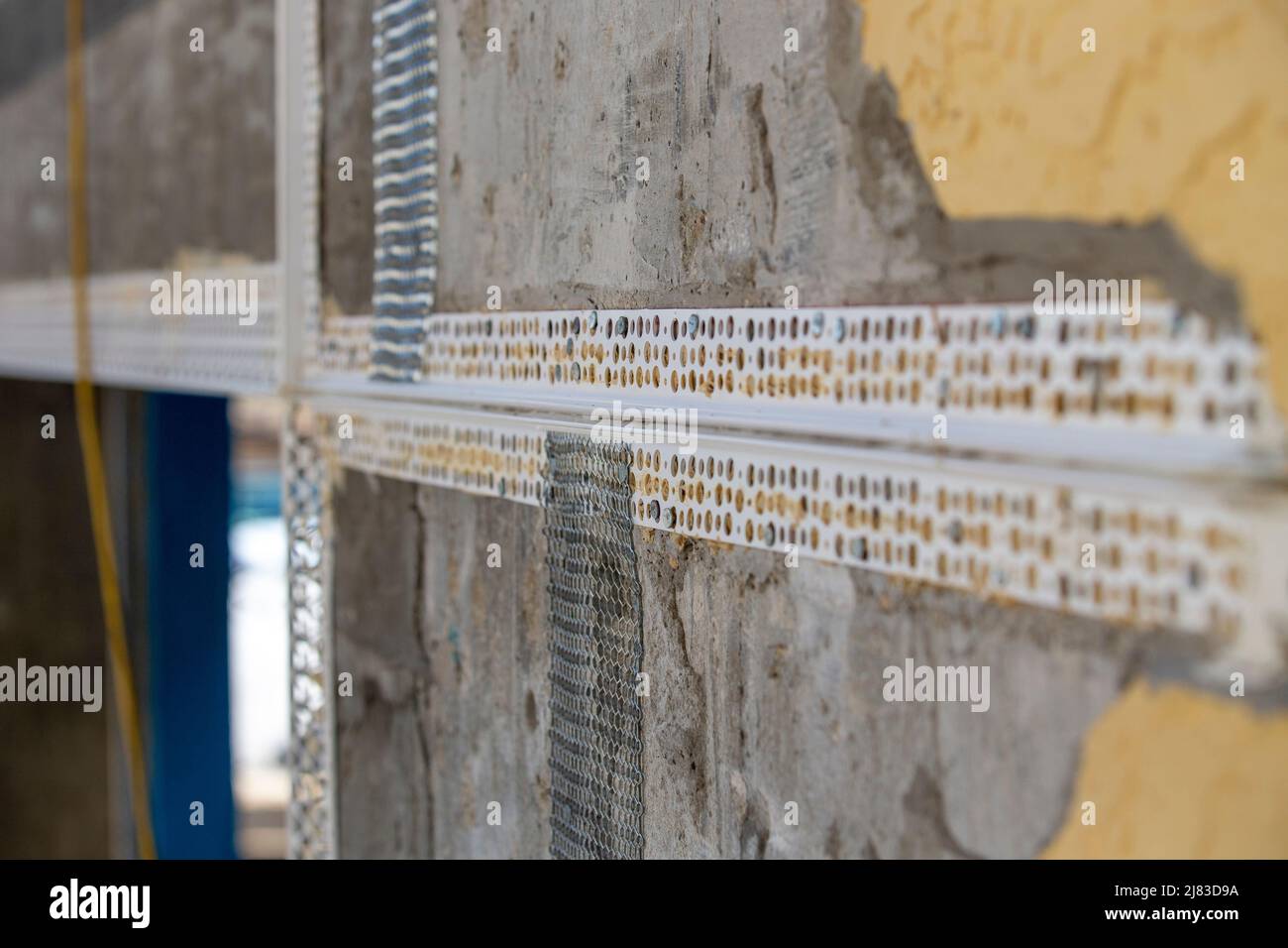 Concrete exterior wall with corner beading and steel mesh during ...