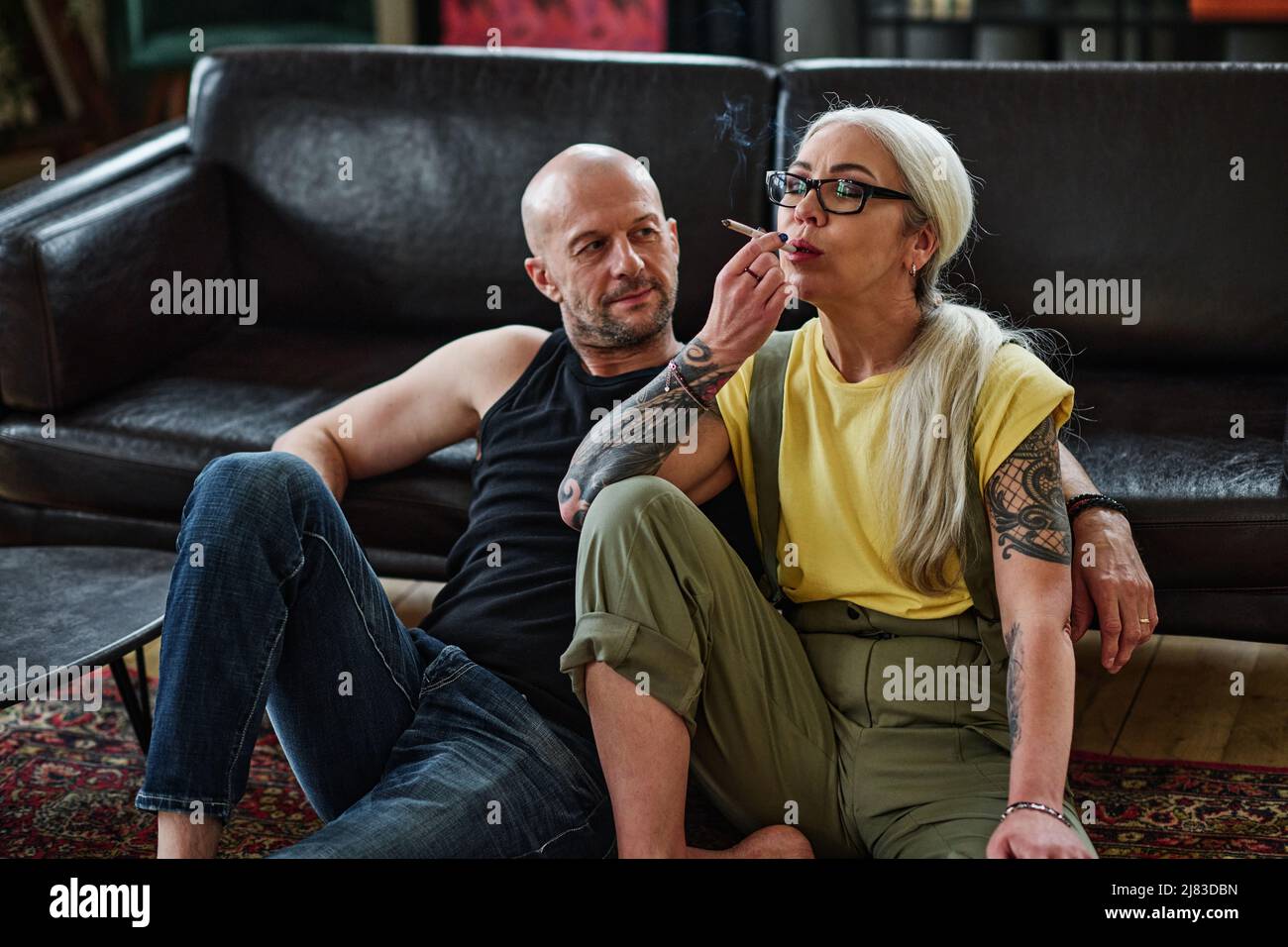 Mature man sitting relaxed on floor in living room looking at his ...