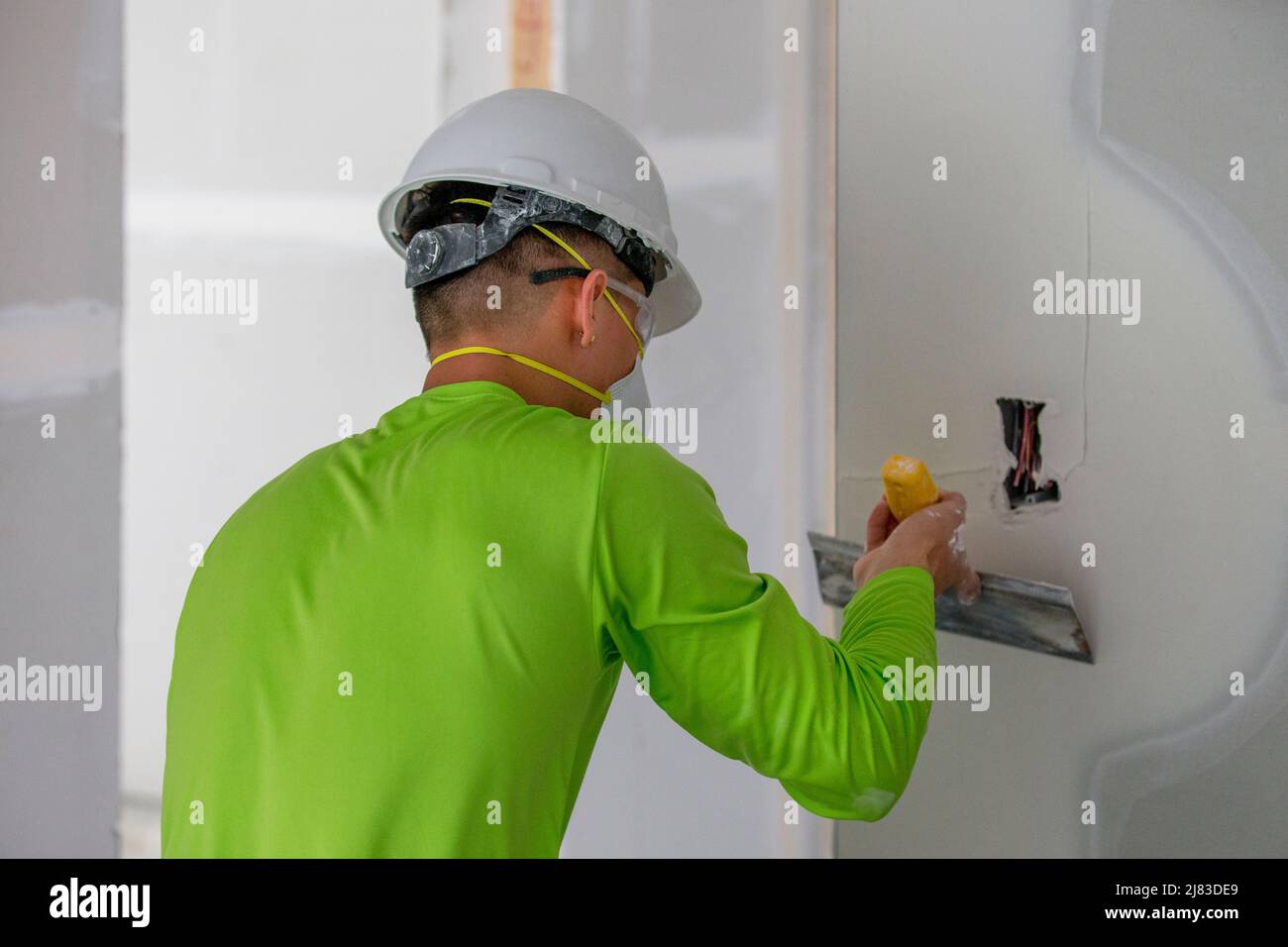 Construction worker - drywall plasterer pulling some plaster mud ...