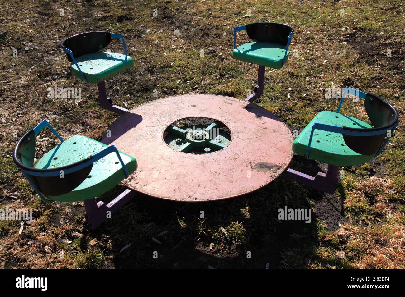 Old rusty disc children's carousel. Desert city and playground with ...