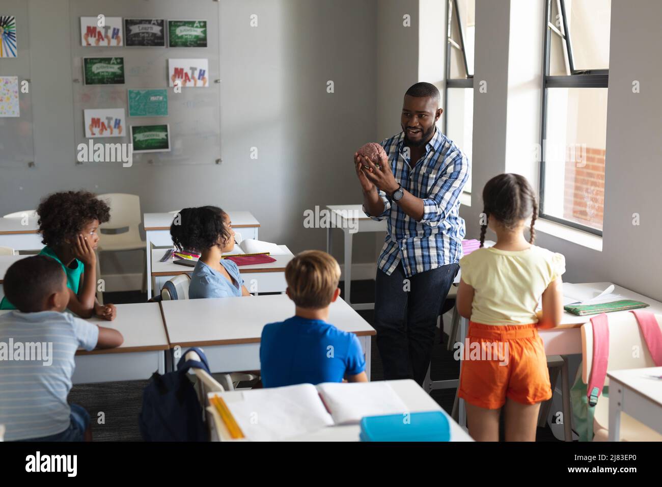 Multiracial elementary students looking at african american young male ...