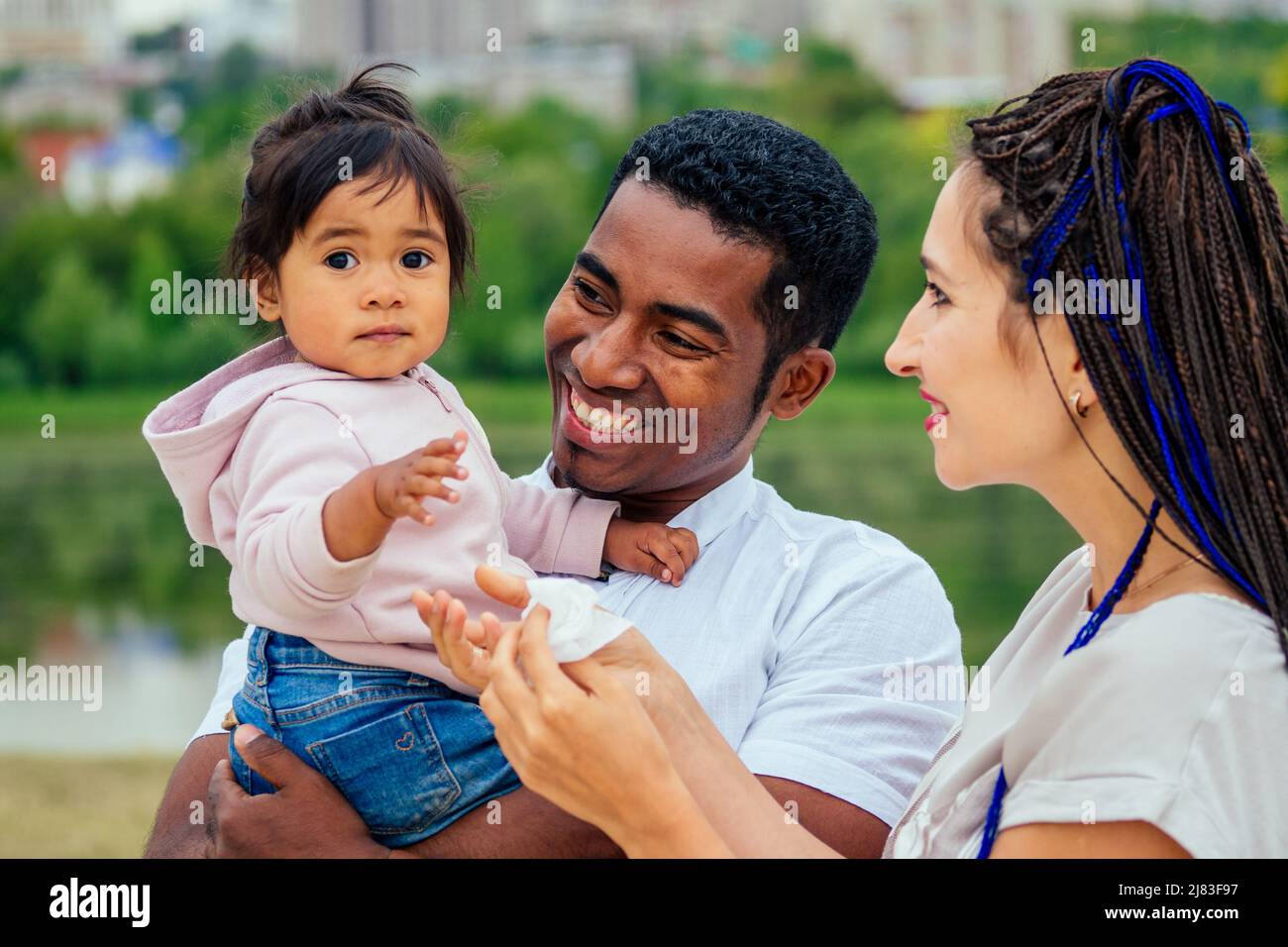 happy family applying hand-sanitizer anti-bacterial gel to daughter ...