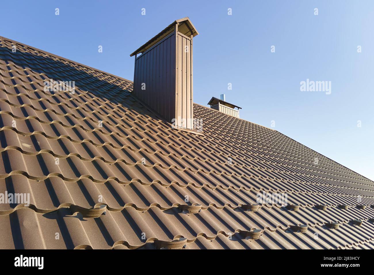 Closeup snow guard for safety in winter on house roof top covered with ...