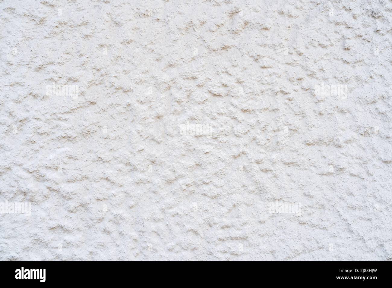 Rough plaster of a white house wall with a number of large and small ...