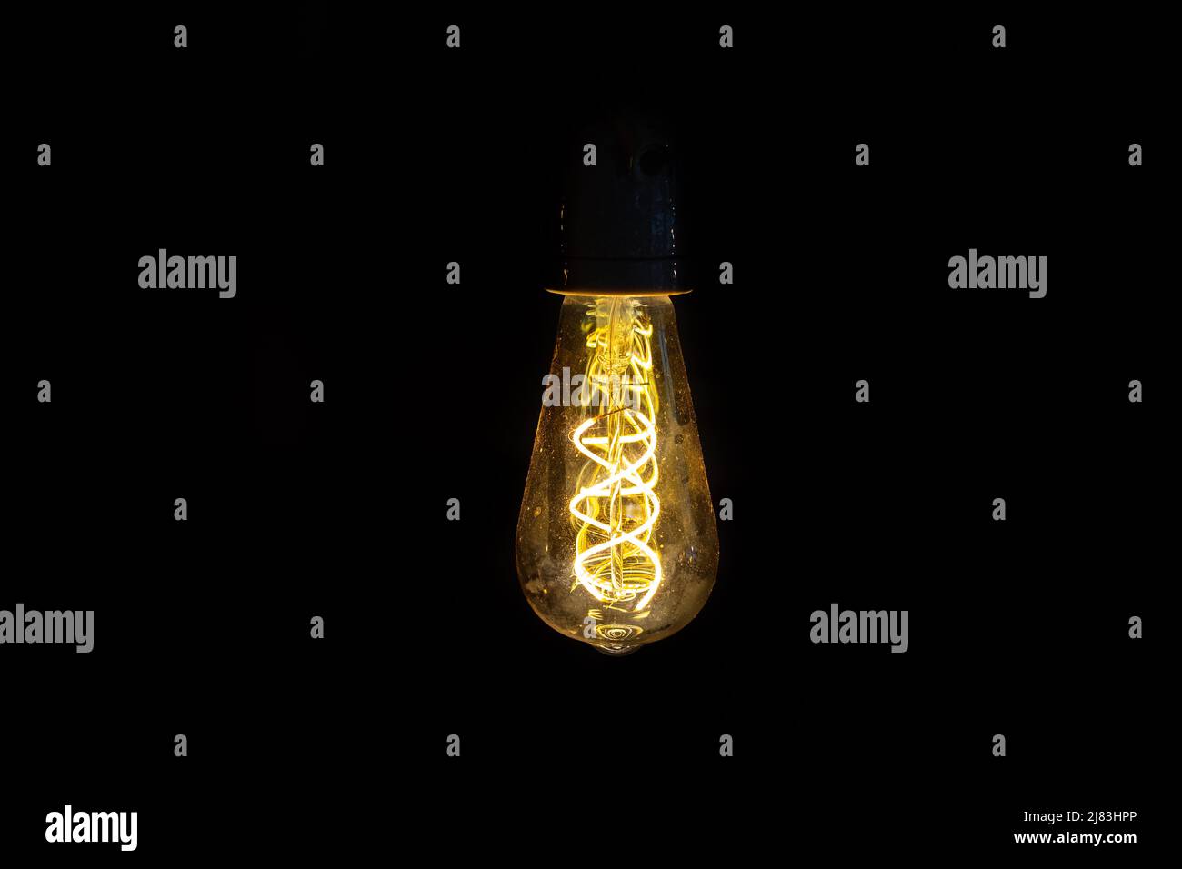 Old lightbulb with yellow filament hanging from the ceiling isolated ...